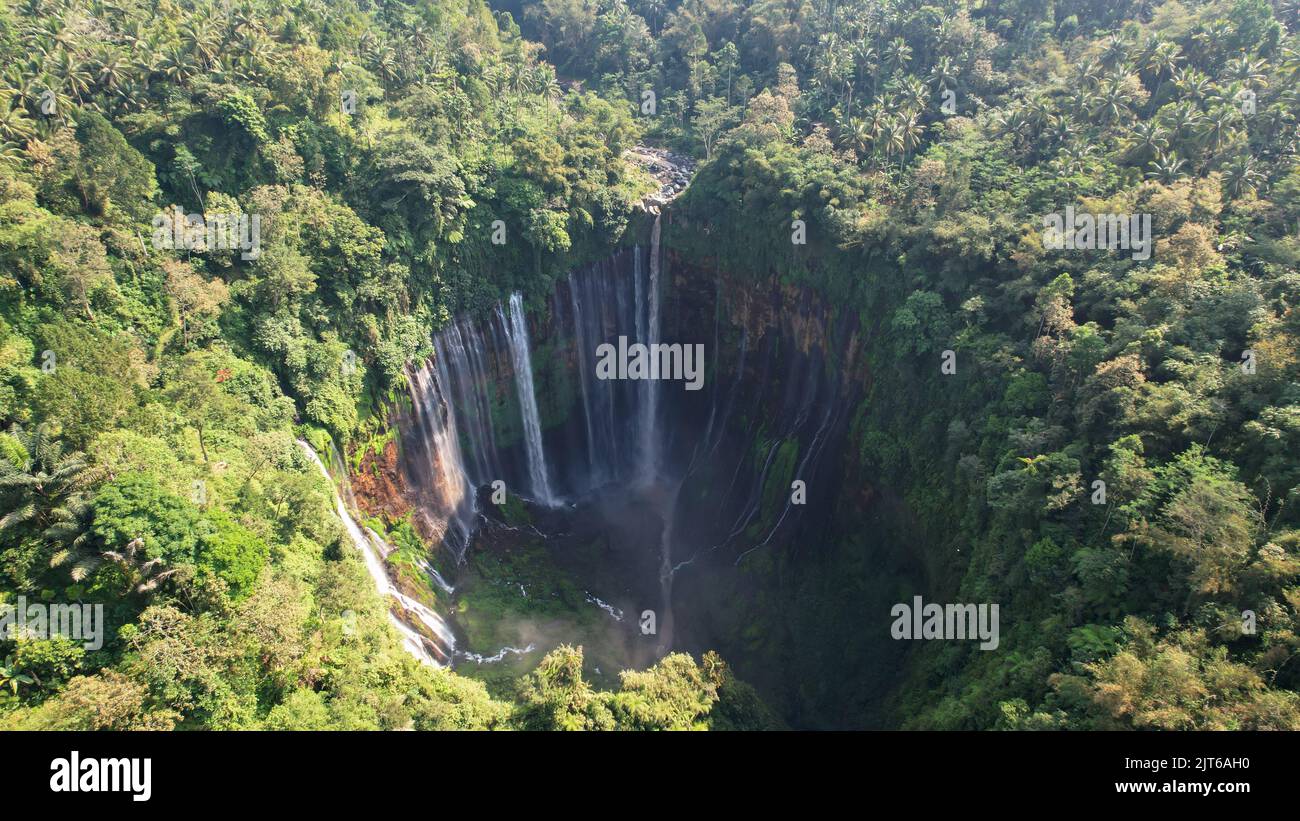 Aerial view of Tumpak Sewu waterfall and Semeru mountain at sunrise ...