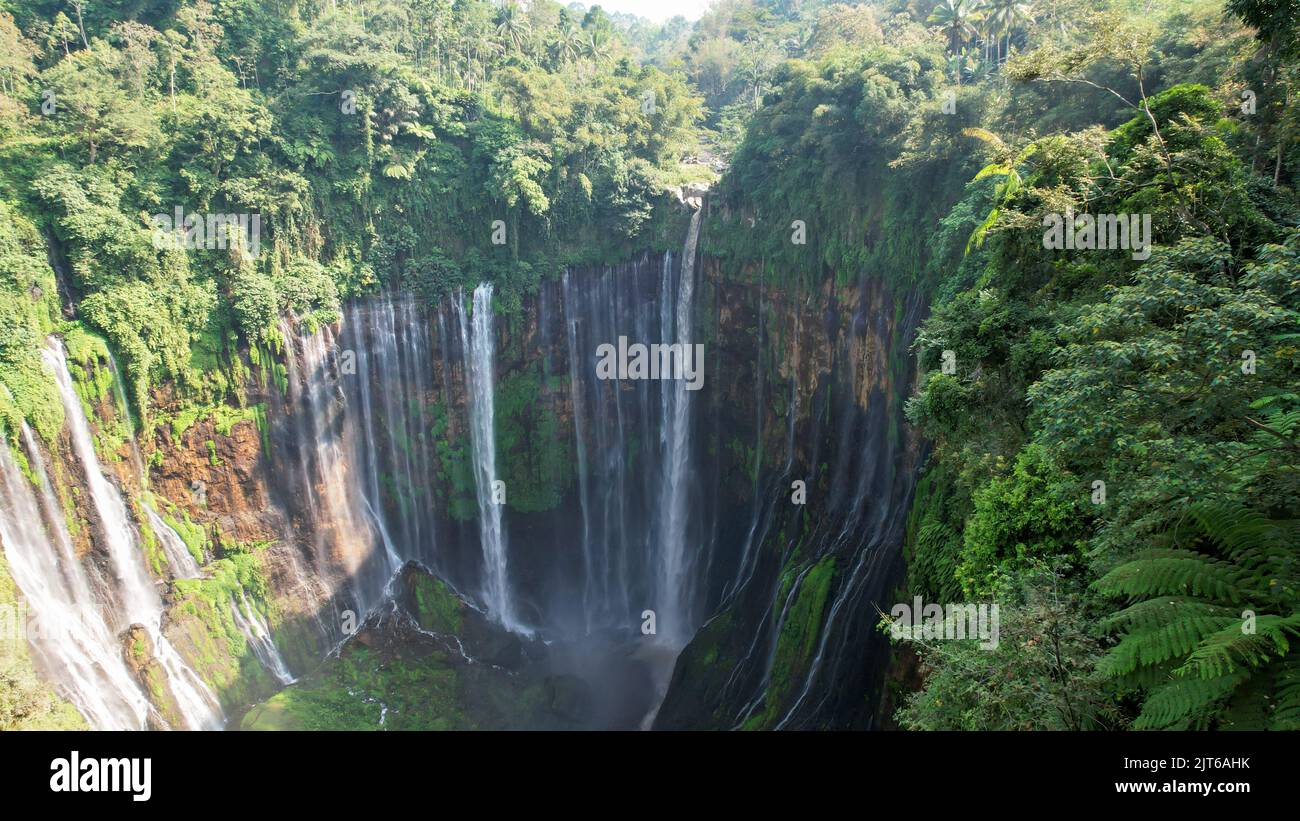 Aerial view of Tumpak Sewu waterfall and Semeru mountain at sunrise ...