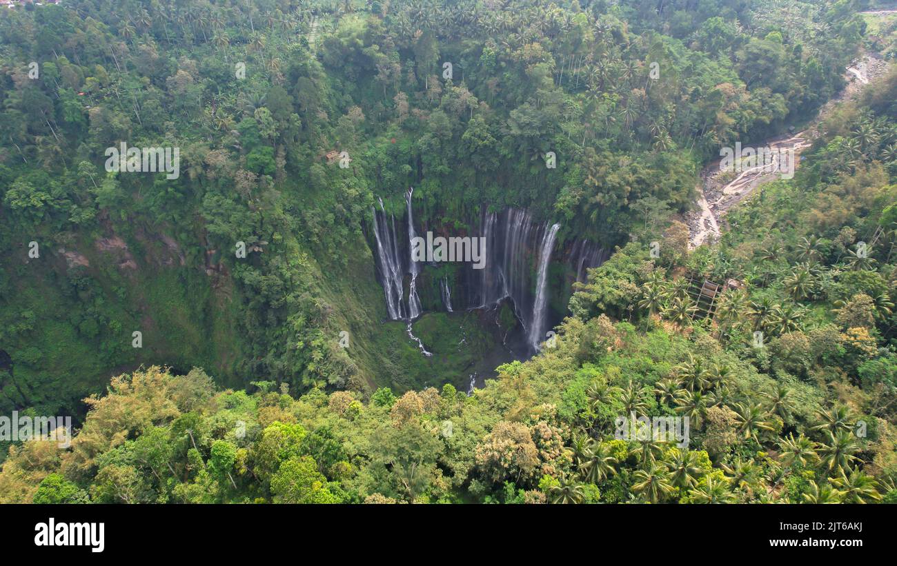 Aerial view of Tumpak Sewu waterfall and Semeru mountain at sunrise ...