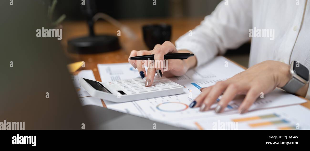 Woman accountant using calculator and computer in office panoramic ...