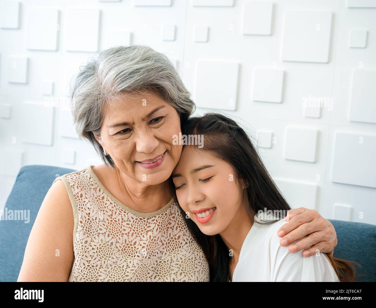 Portrait of happy Asian senior, mother white hair embracing her beautiful daughter with closing ...
