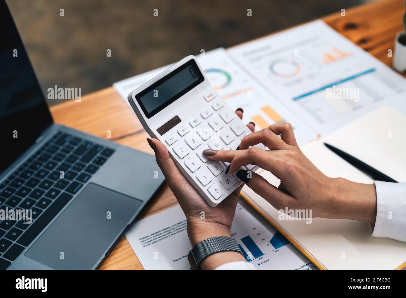 business woman or accountant working on calculator to calculate ...