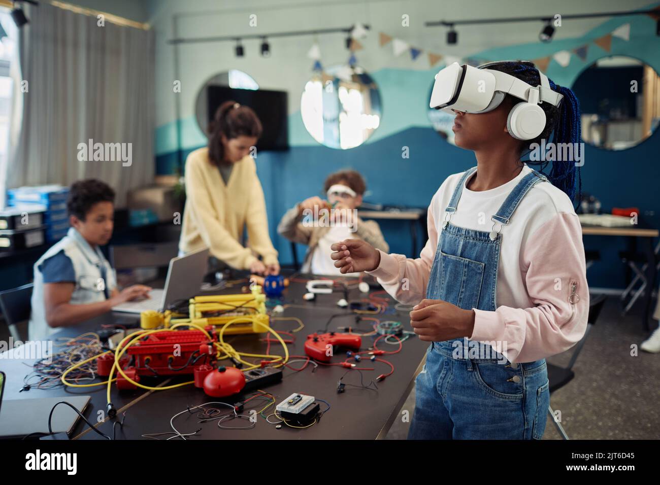 Portrait of young black girl using VR technology in engineering class ...