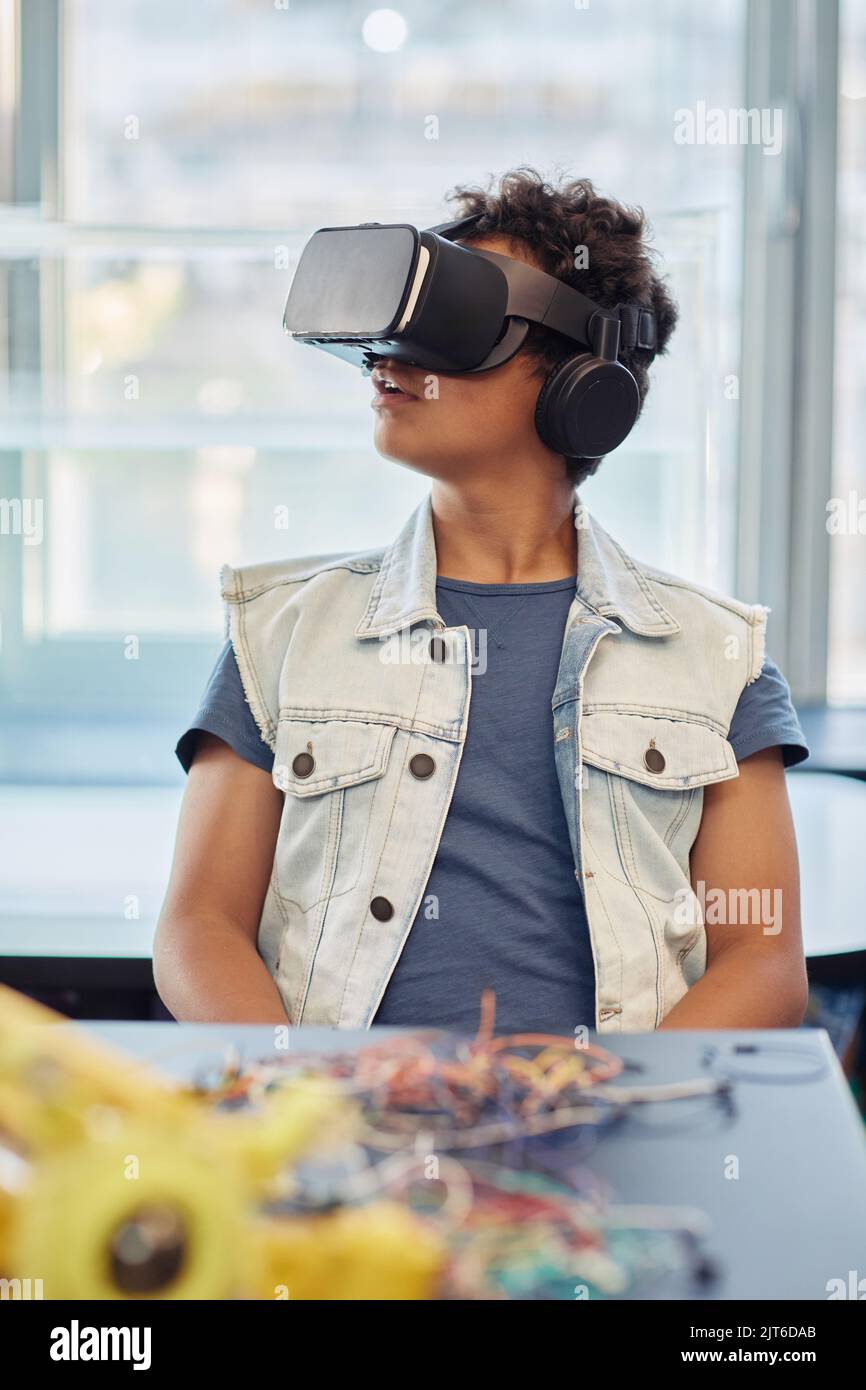 Vertical portrait of black teenage boy using VR technology in ...