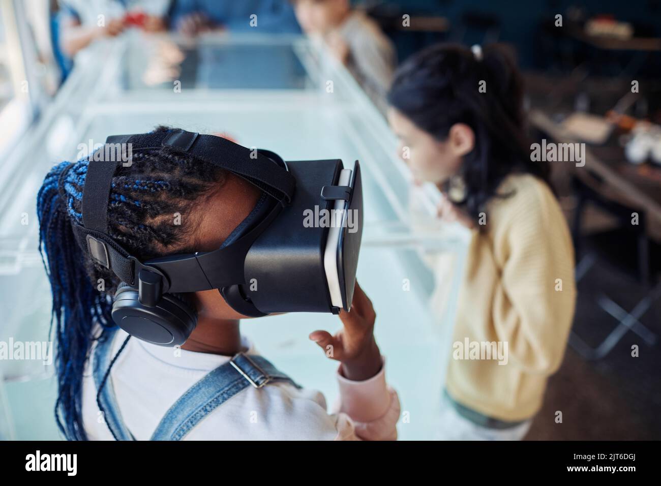 High angle portrait of black teenage girl wearing VR headset in scince ...