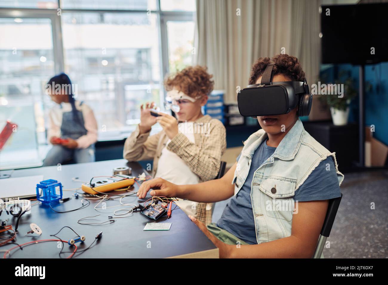Portrait of two children building robots in engineering class and using ...