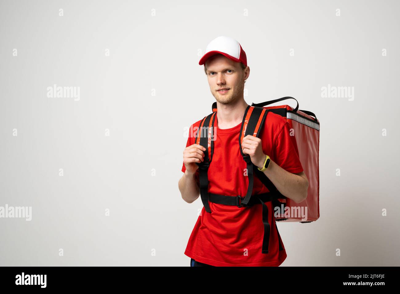 Delivery man in a red uniform carry thermal backpack full of food ...