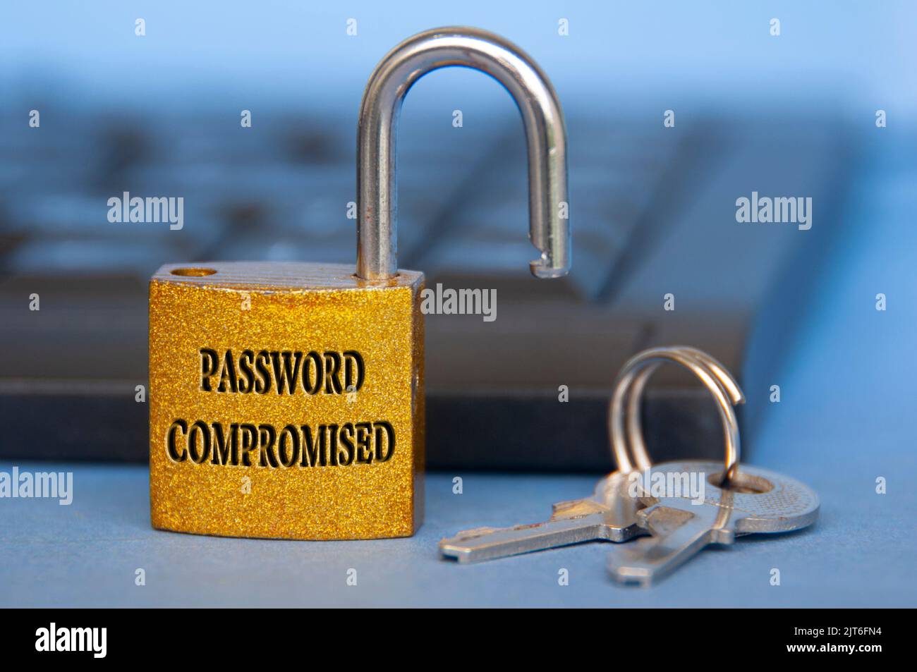 Password compromised text engraved on padlock with blurred keyboard ...