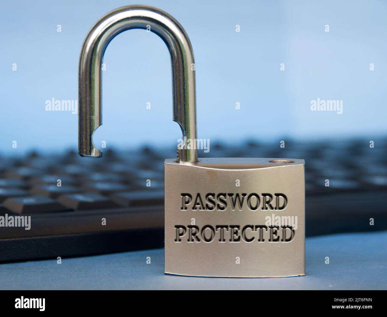 Password protected text engraved on padlock with blurred keyboard ...