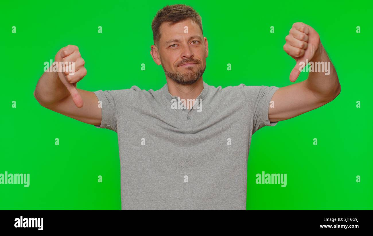 Upset bearded handsome young man showing thumbs down sign gesture ...