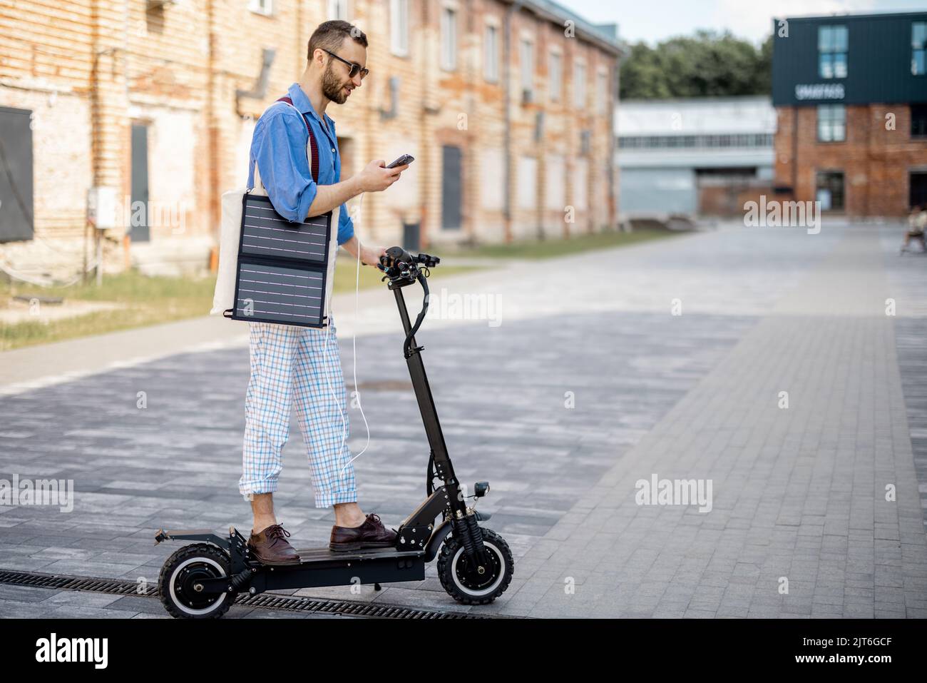 Stylish guy drives electric scooter and uses phone on the move Stock ...