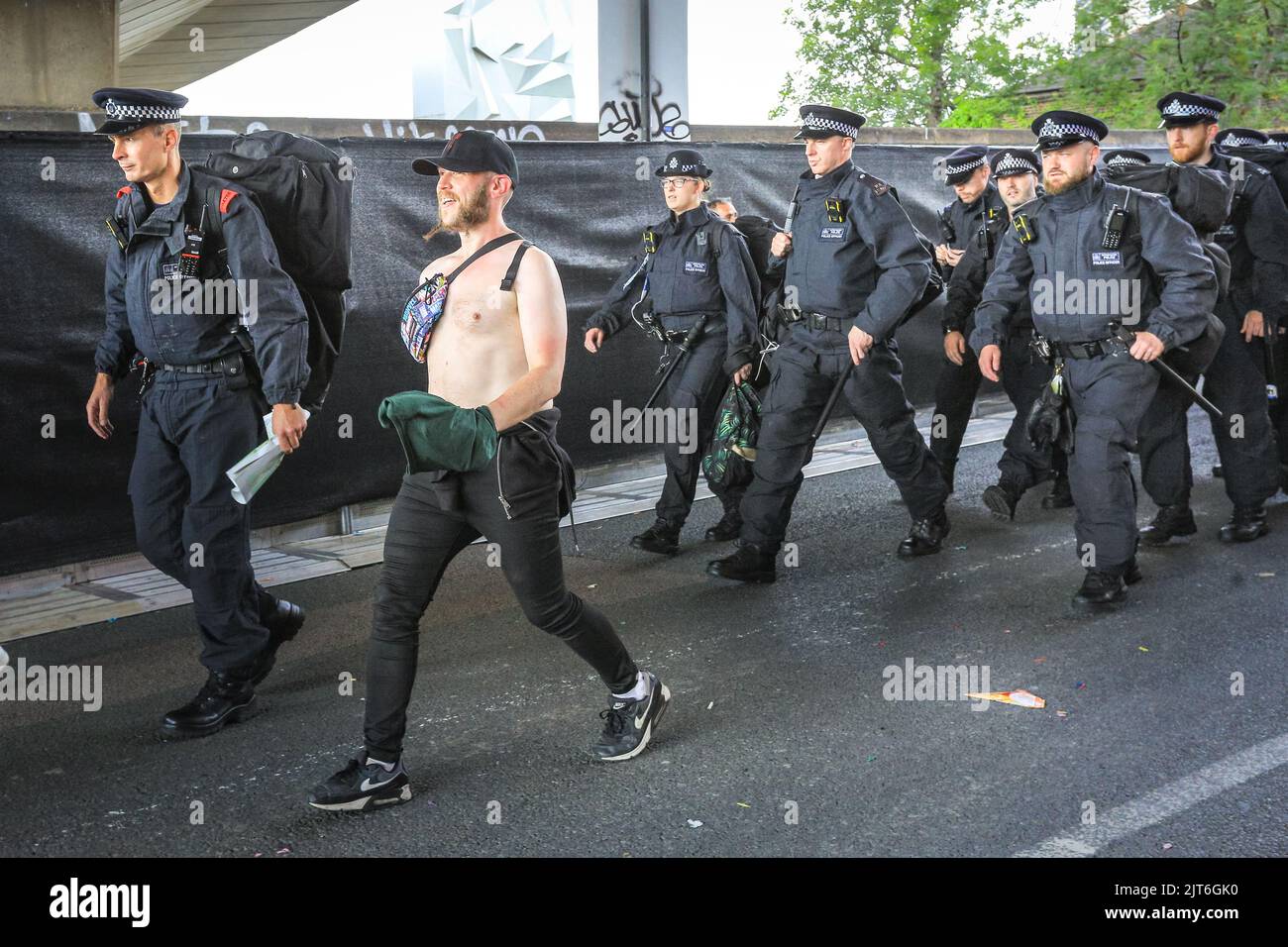 London, UK. 28th Aug, 2022. A reveller walks along a group of police ...