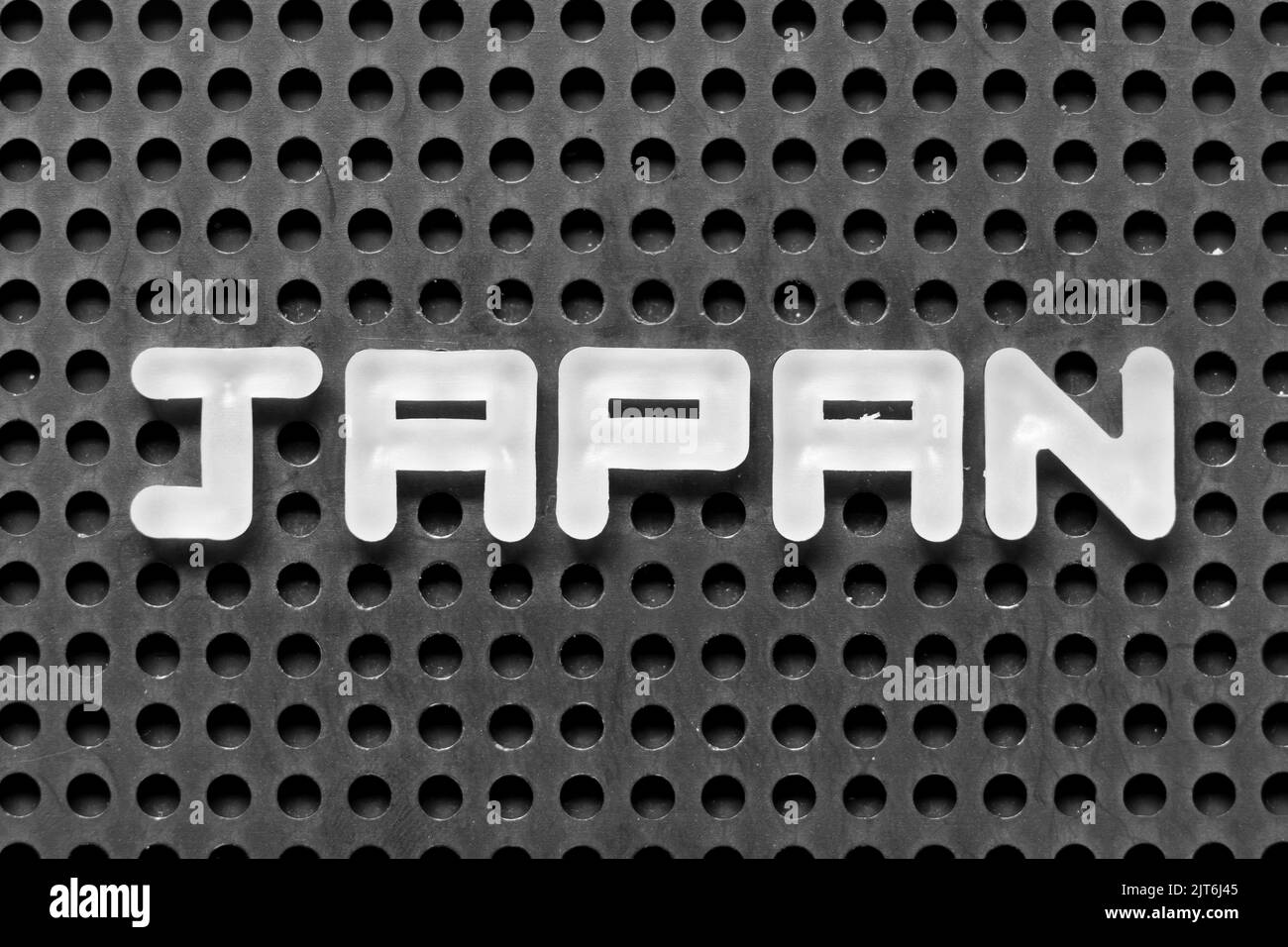 White alphabet letter in word japan on black pegboard background Stock ...