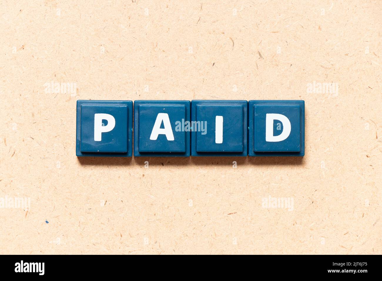 Tile letter in english word paid on wood background Stock Photo - Alamy