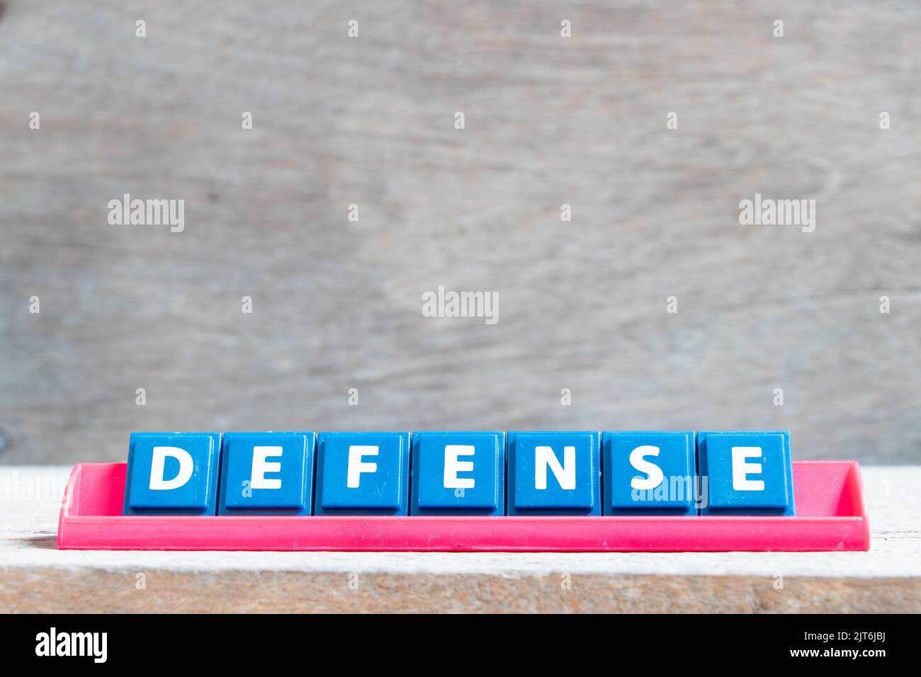 Tile alphabet letter with word defense in red color rack on wood ...