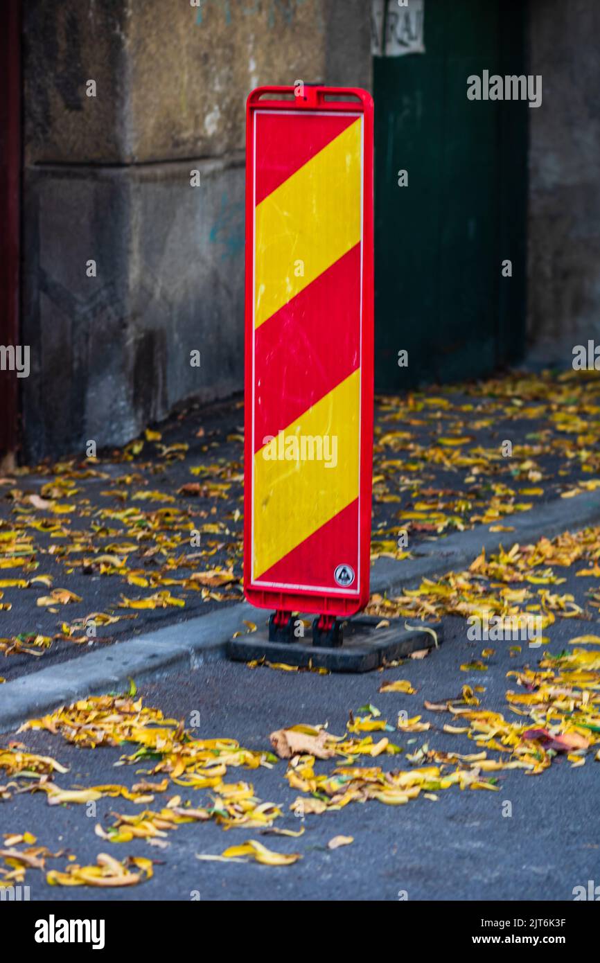 Parking spot with orange safety cones standing and autumn leaves in ...
