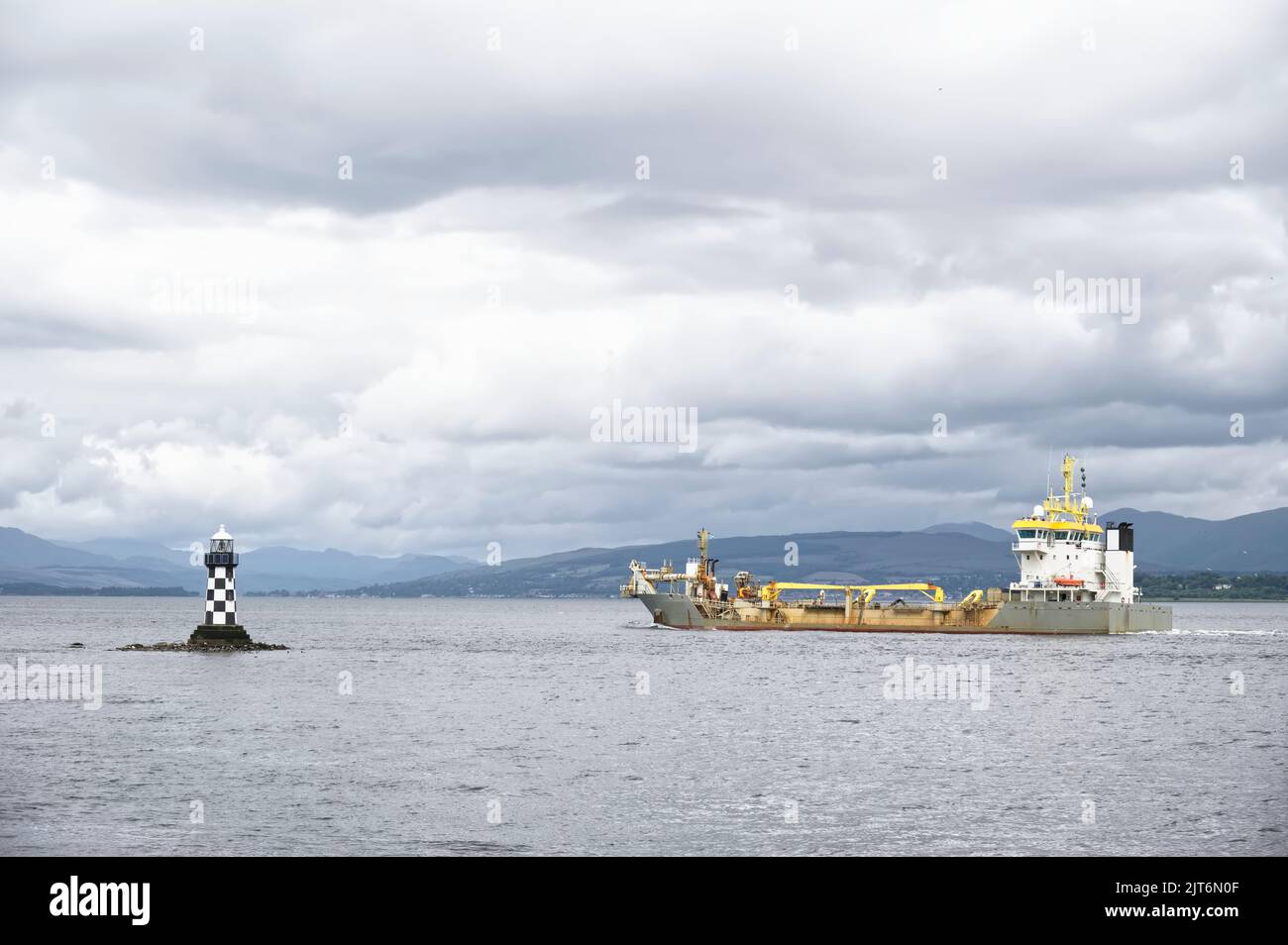 Tugboat transporting floating storage container platform and lighthouse ...