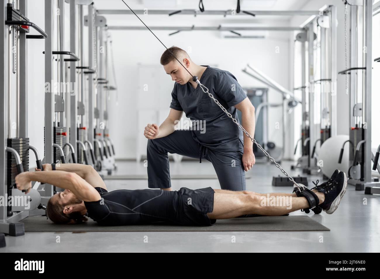 Man doing exercises on decompression simulators with the help of ...