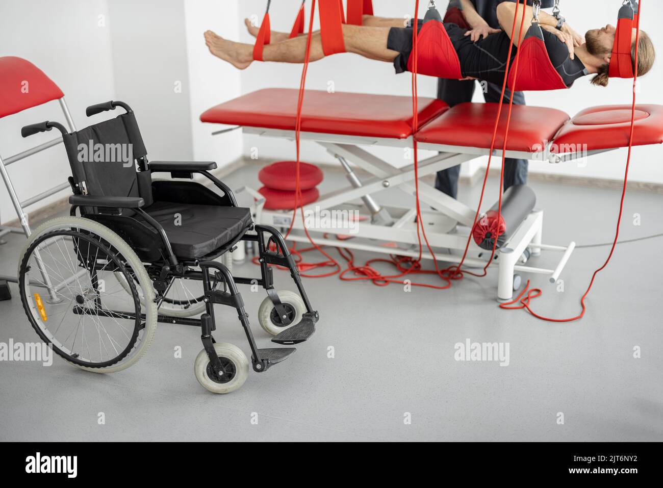 Rehabilitation specialist doing active treatment on suspension straps ...