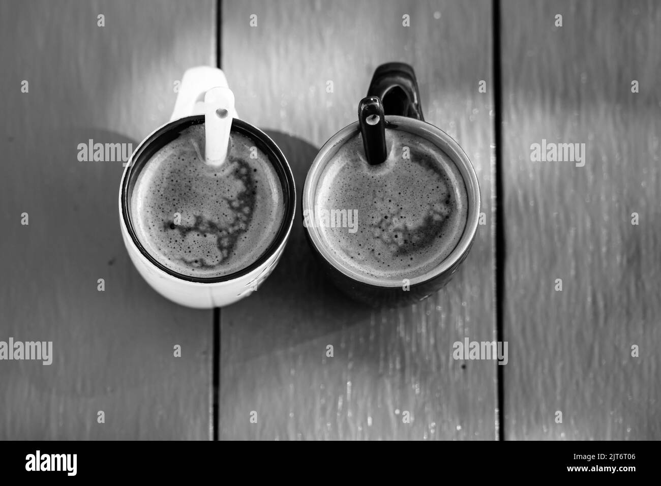 A grayscale closeup of two mugs with hot black coffee Stock Photo - Alamy