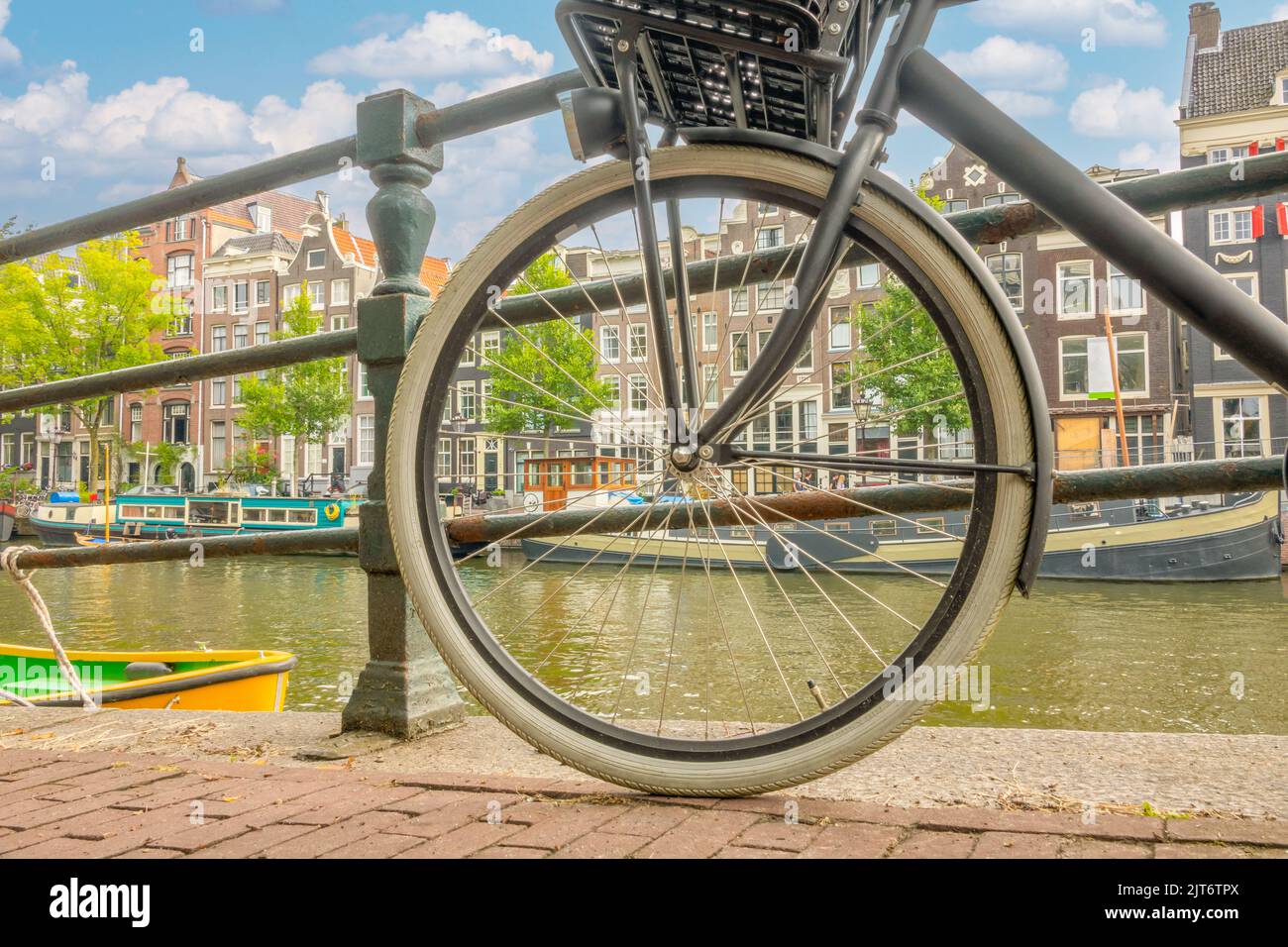 Netherlands. Summer day in Amsterdam. View through a bicycle wheel to ...