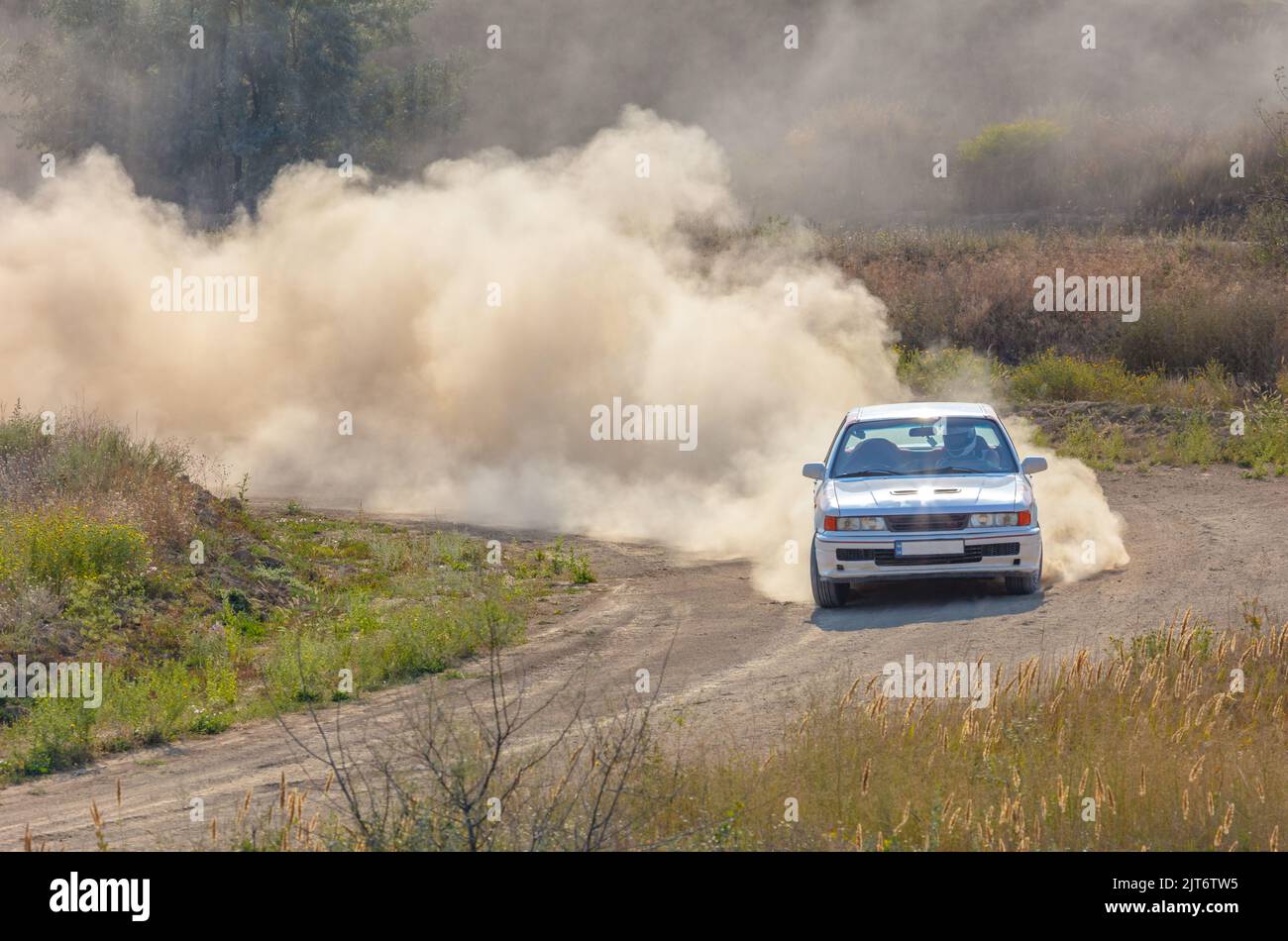 Sunny summer day. Dusty rally track. Sports car does a lot of dust in ...