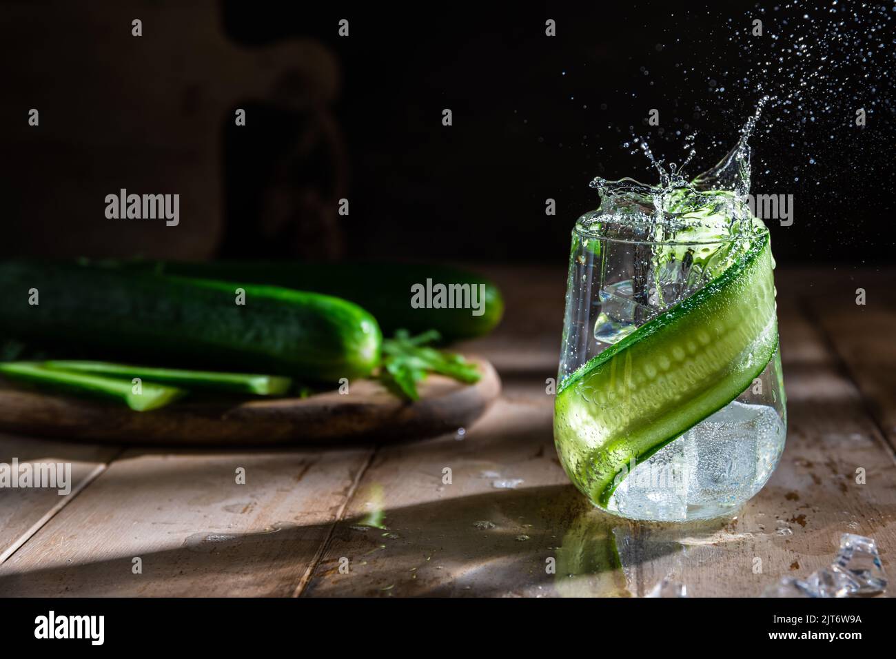 cucumber soft summer drink on a dark background with splashes of water ...