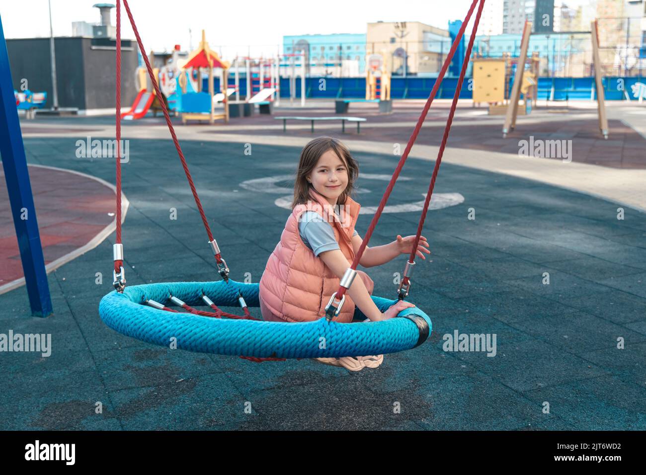 cute girl walks and swings on a swing outdoors Stock Photo - Alamy