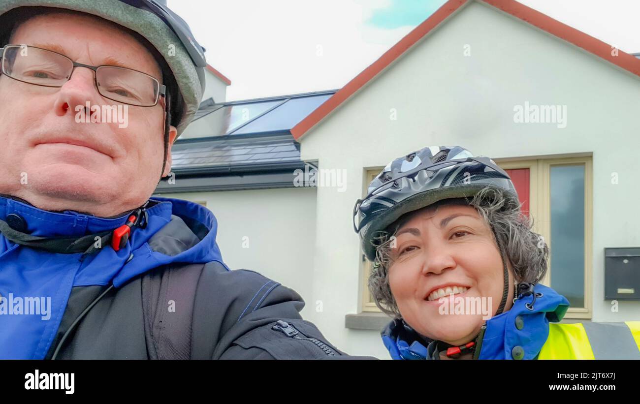 Close up of senior couple of cyclists wearing bicycle helmets ready for ...