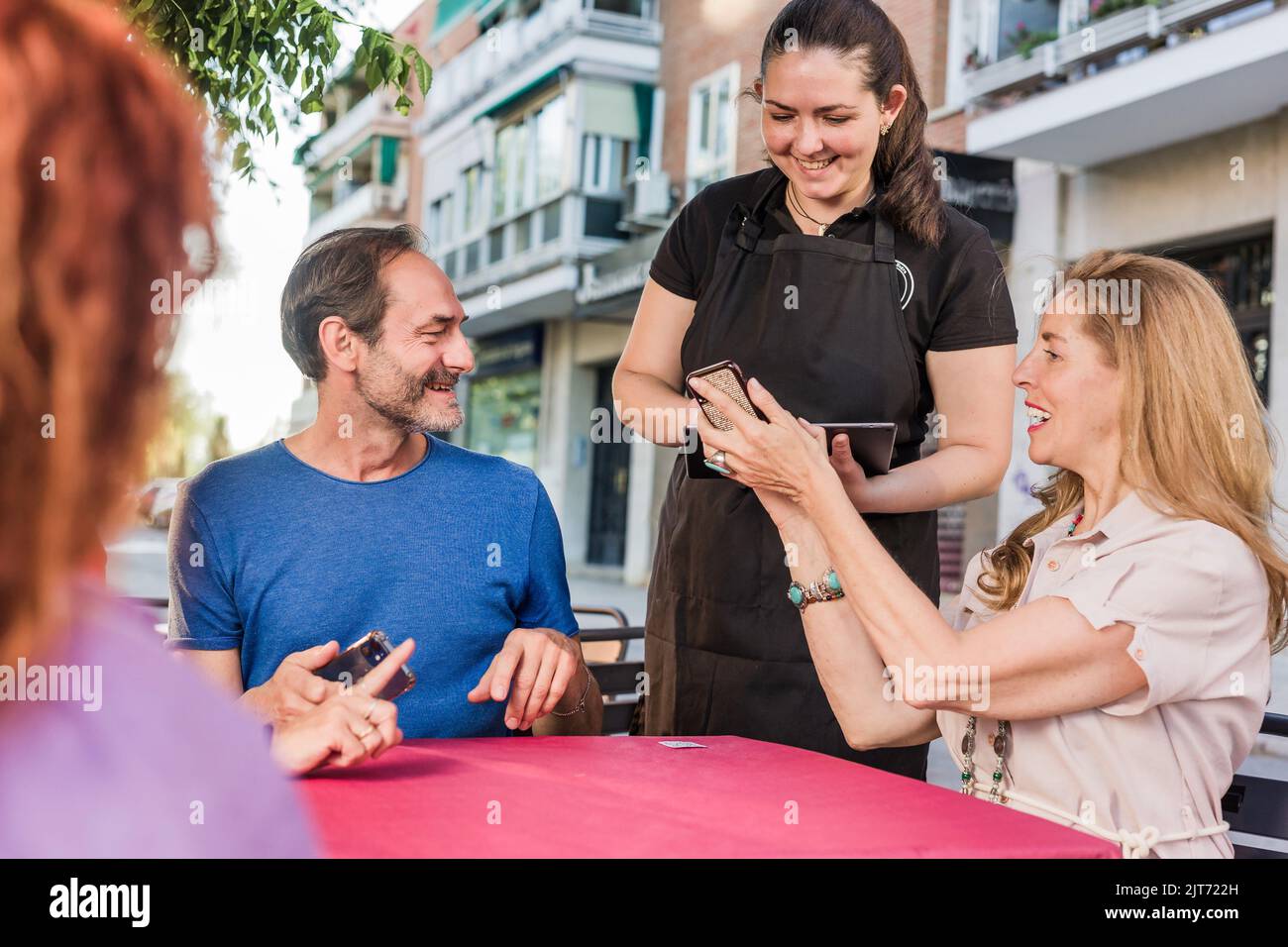 mature group order food in restaurant. waitress using smartphone and ...