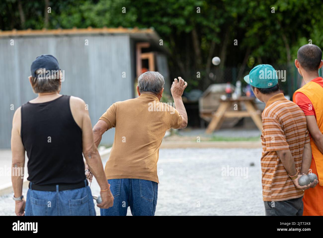 A Petanque player holds the balls behind his back Stock Photo - Alamy