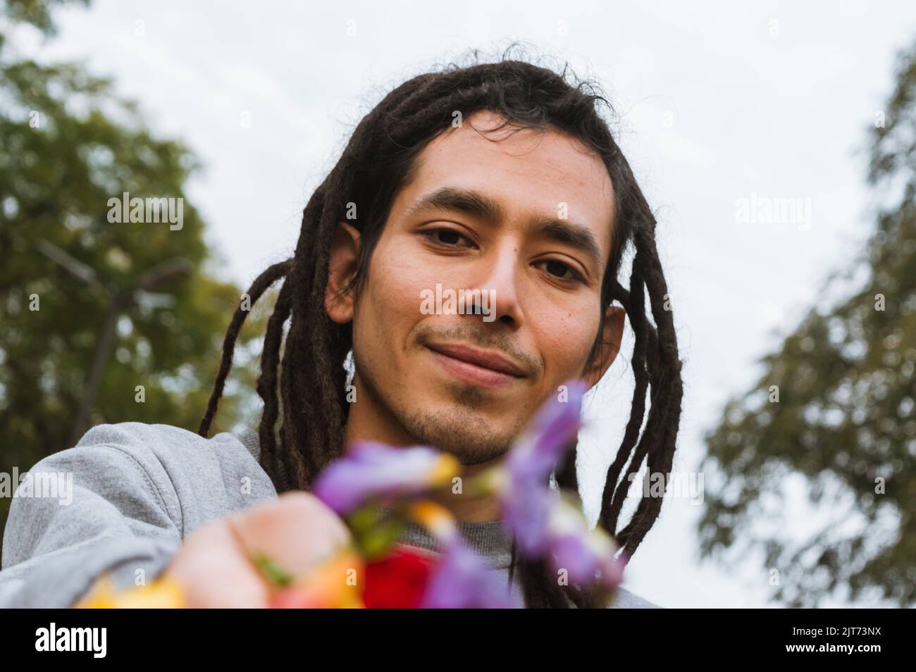 portrait of young venezuelan man with dreadlocks smiling and looking at ...