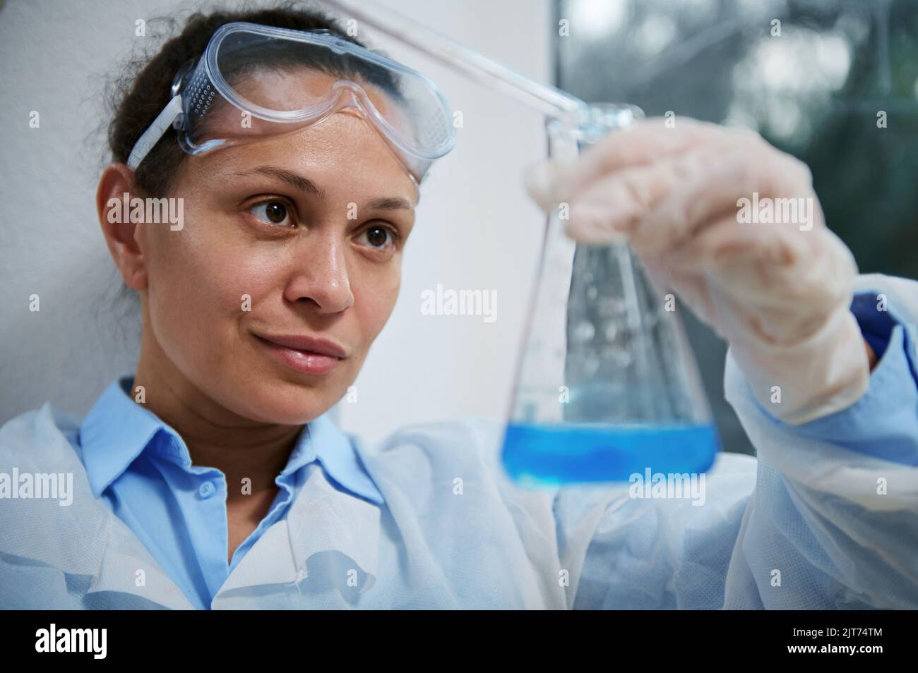 Pharmaceutical scientist in goggles, using a laboratory pipette ...