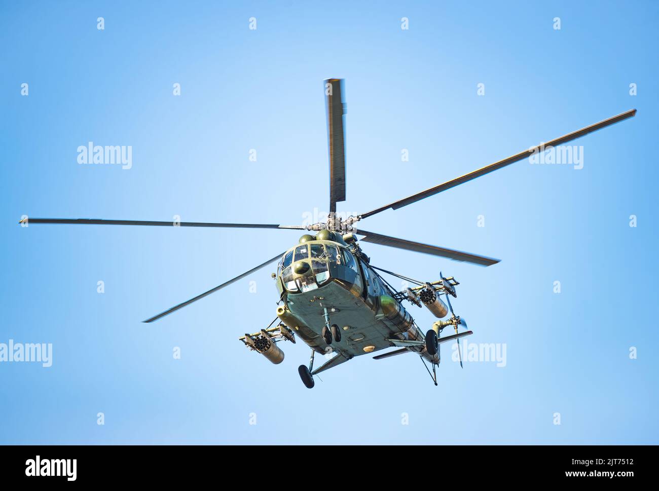 Very close frontal view of an attack helicopter against the sky, with ...
