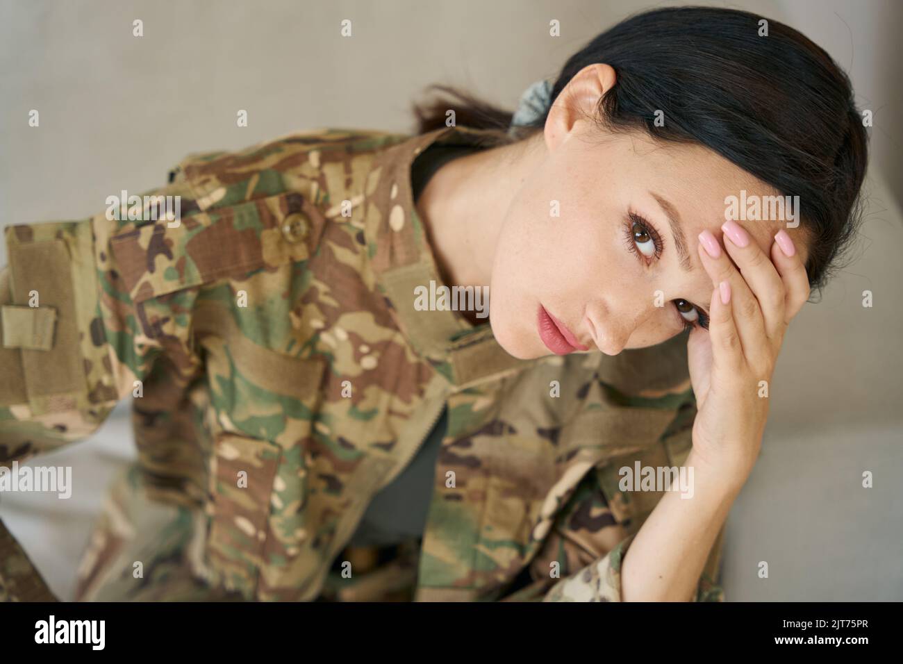 Woman in military uniform holding her head Stock Photo - Alamy