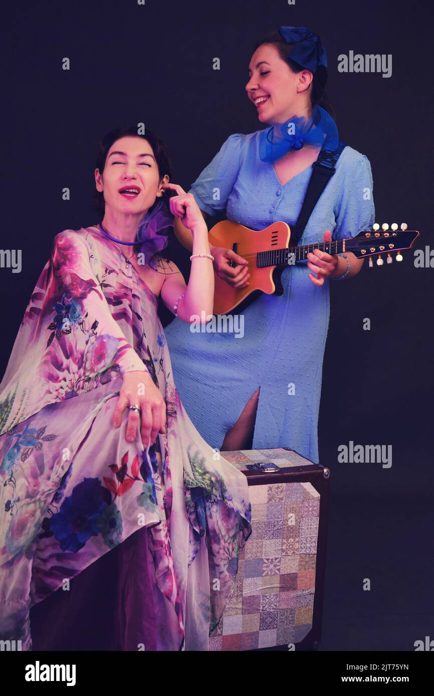 Women musicians in blue dresses with musical instruments on a black ...