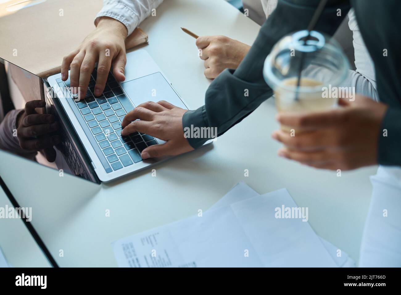 Colleagues, multiracial female and caucasian male, use small laptop for ...