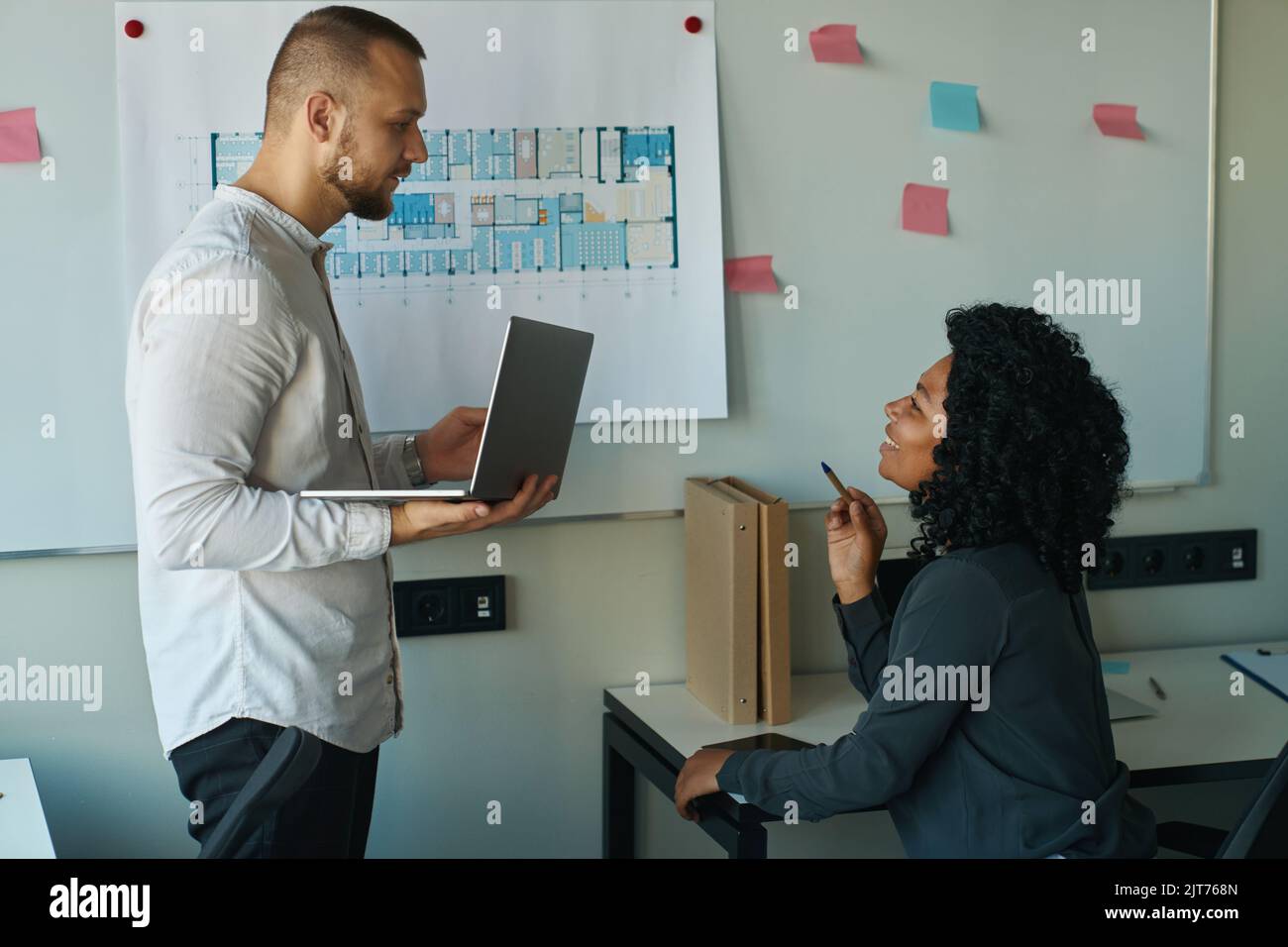 Man manager discussing working moments with colleague Stock Photo - Alamy
