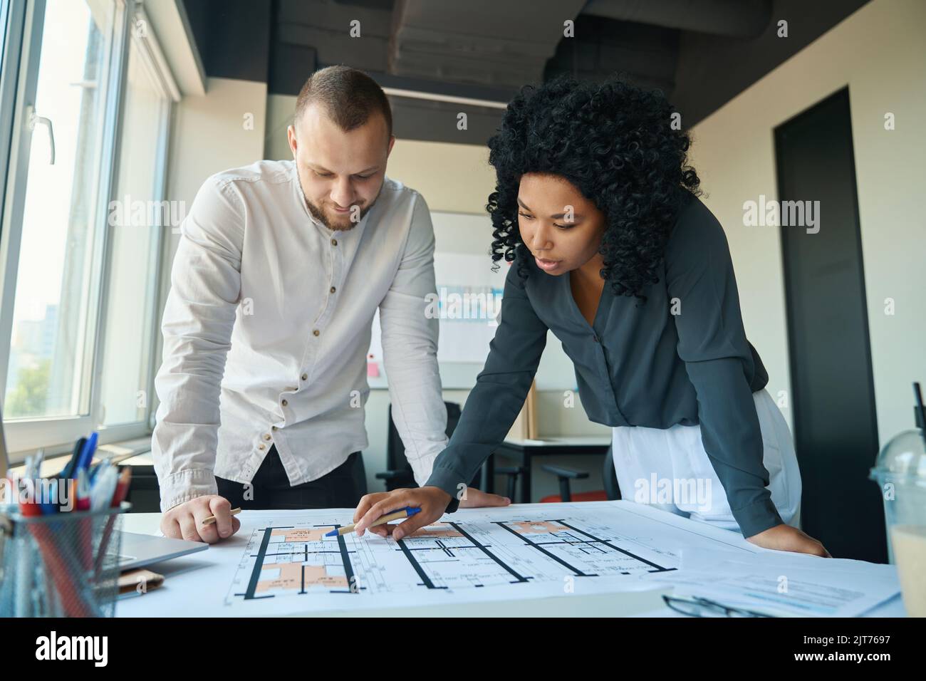 Enthusiastic office staff discussing working draft together Stock Photo ...