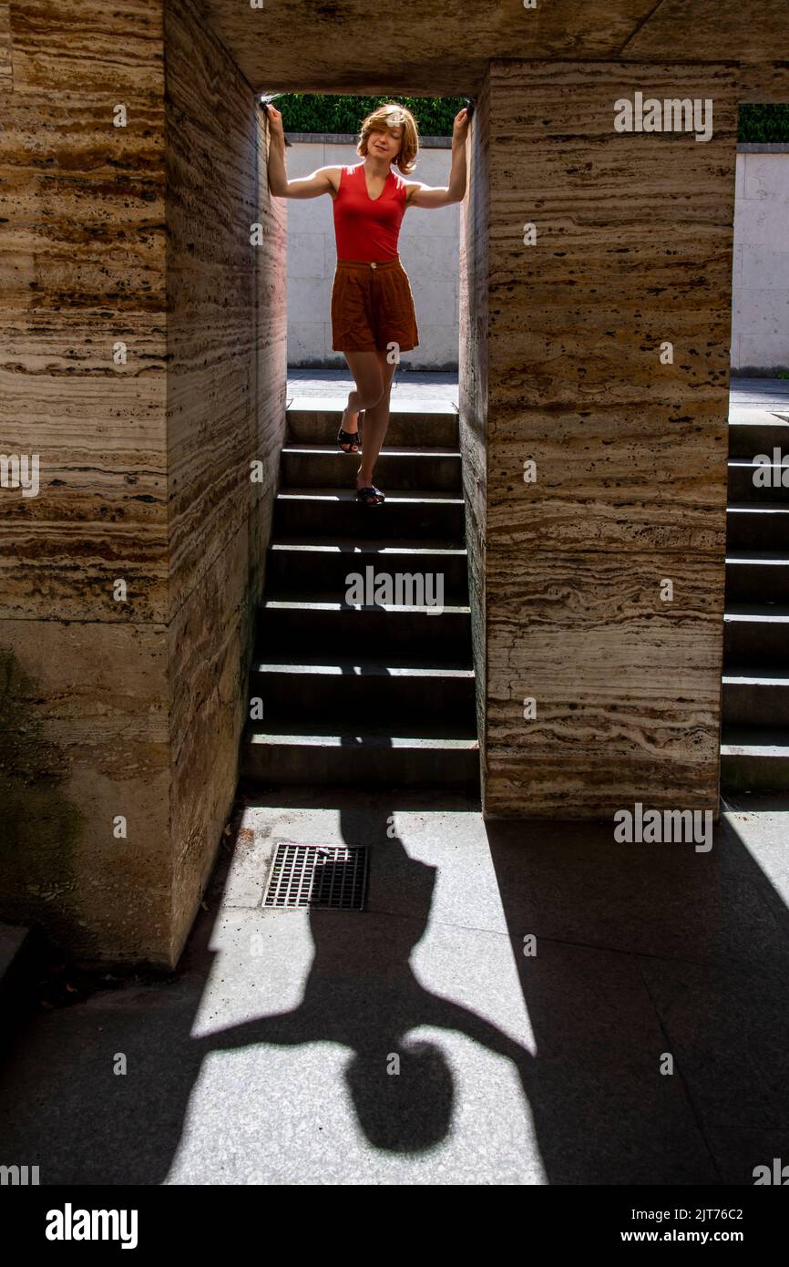 Blond slim woman dressed in red and her shadow on the steps Stock Photo ...