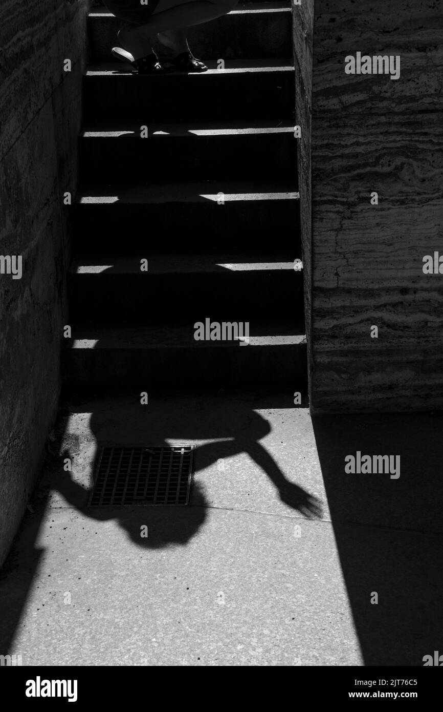 Shadow projection of a woman, falling on the steps of the staircase ...