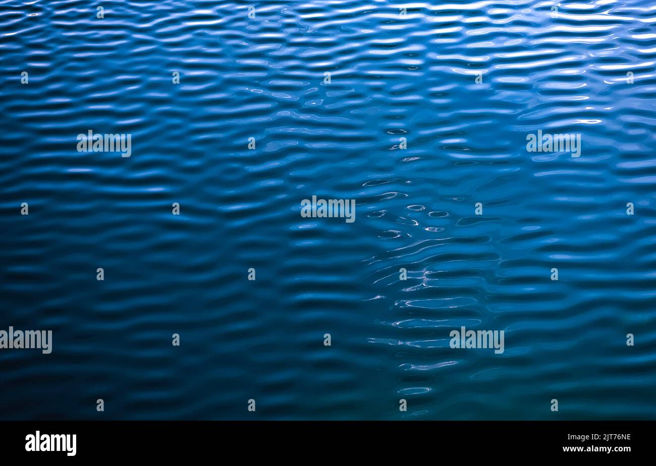 Smooth water blue. water background and sun reflections. textured ...