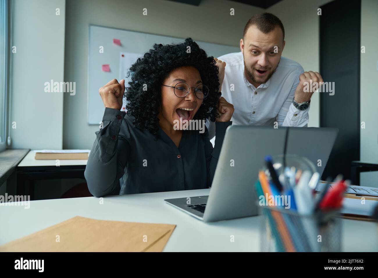 Man and woman at the computer rejoice at a successful deal Stock Photo ...