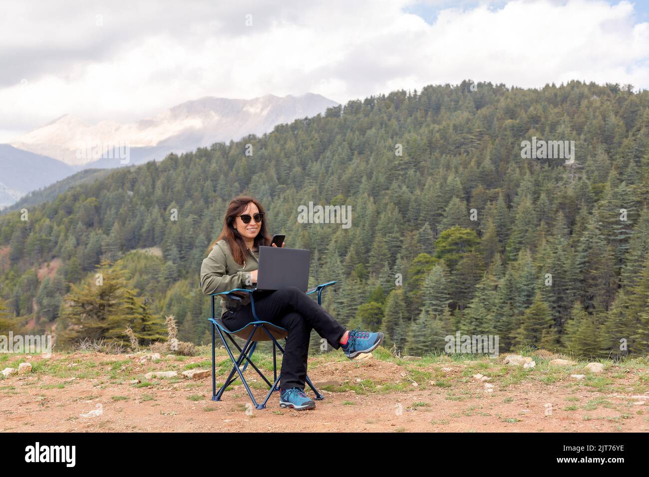 Woman working with her computer in nature, working with a computer in ...
