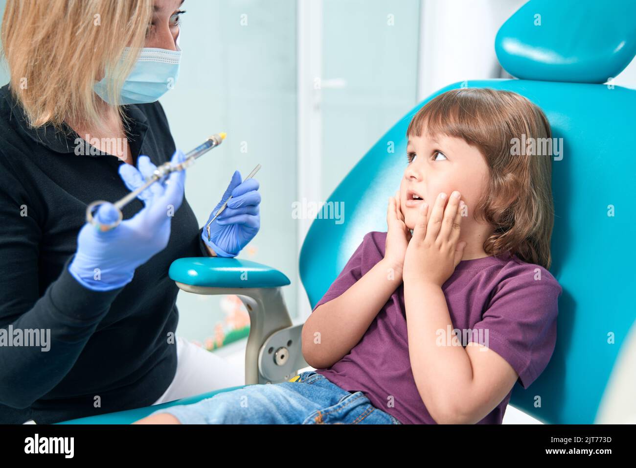 Frightened female child staring at pediatric dentist before anesthetic ...