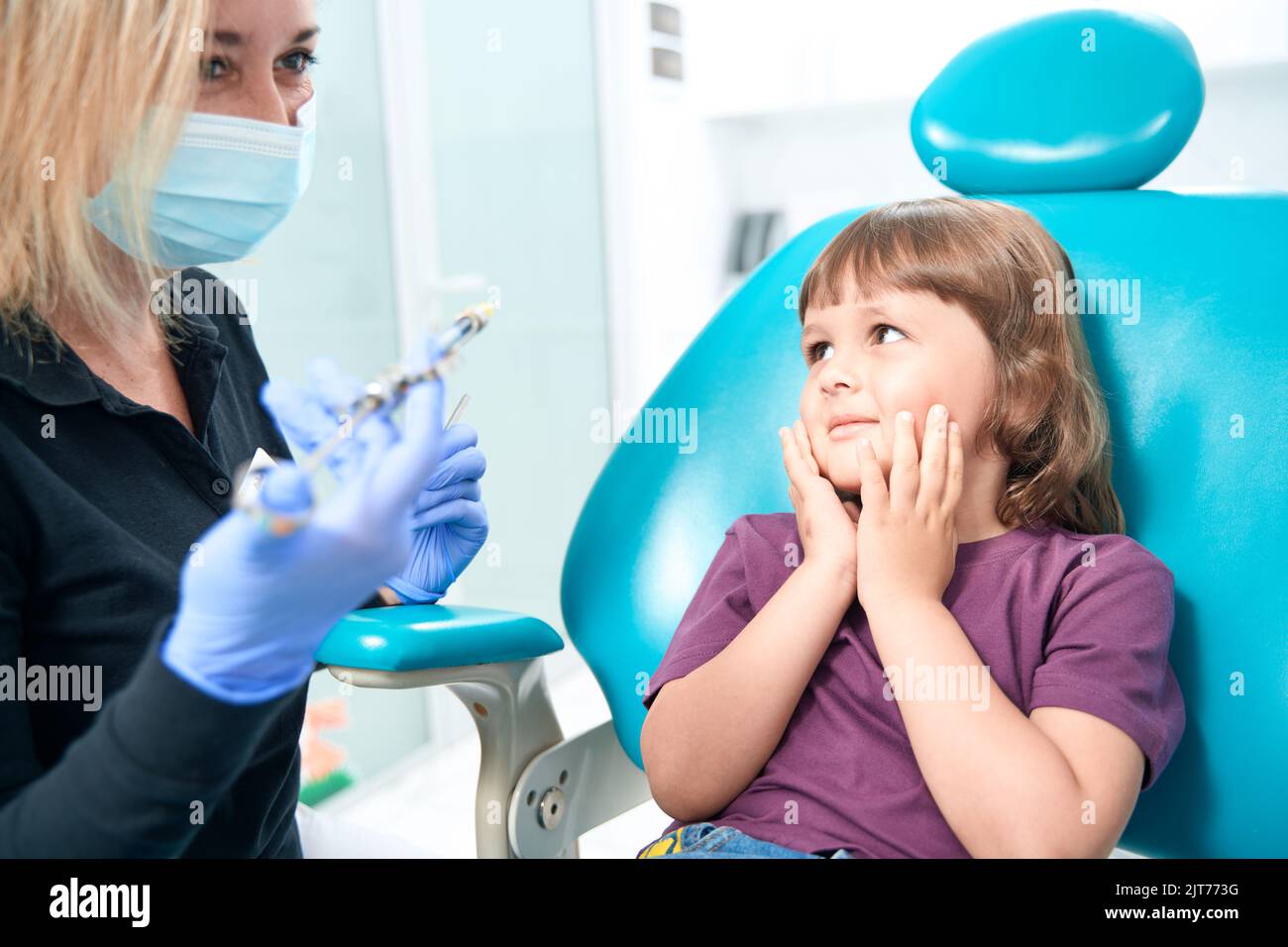 Scared child looking at female doctor before anesthetic injection Stock ...