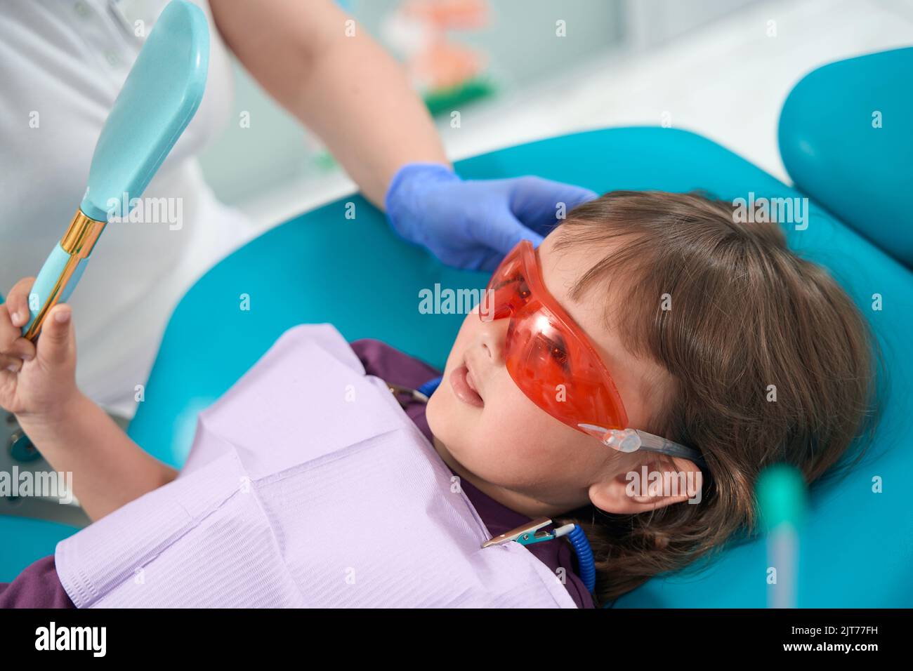Doctor protecting patient eyes with safety goggles before dental ...