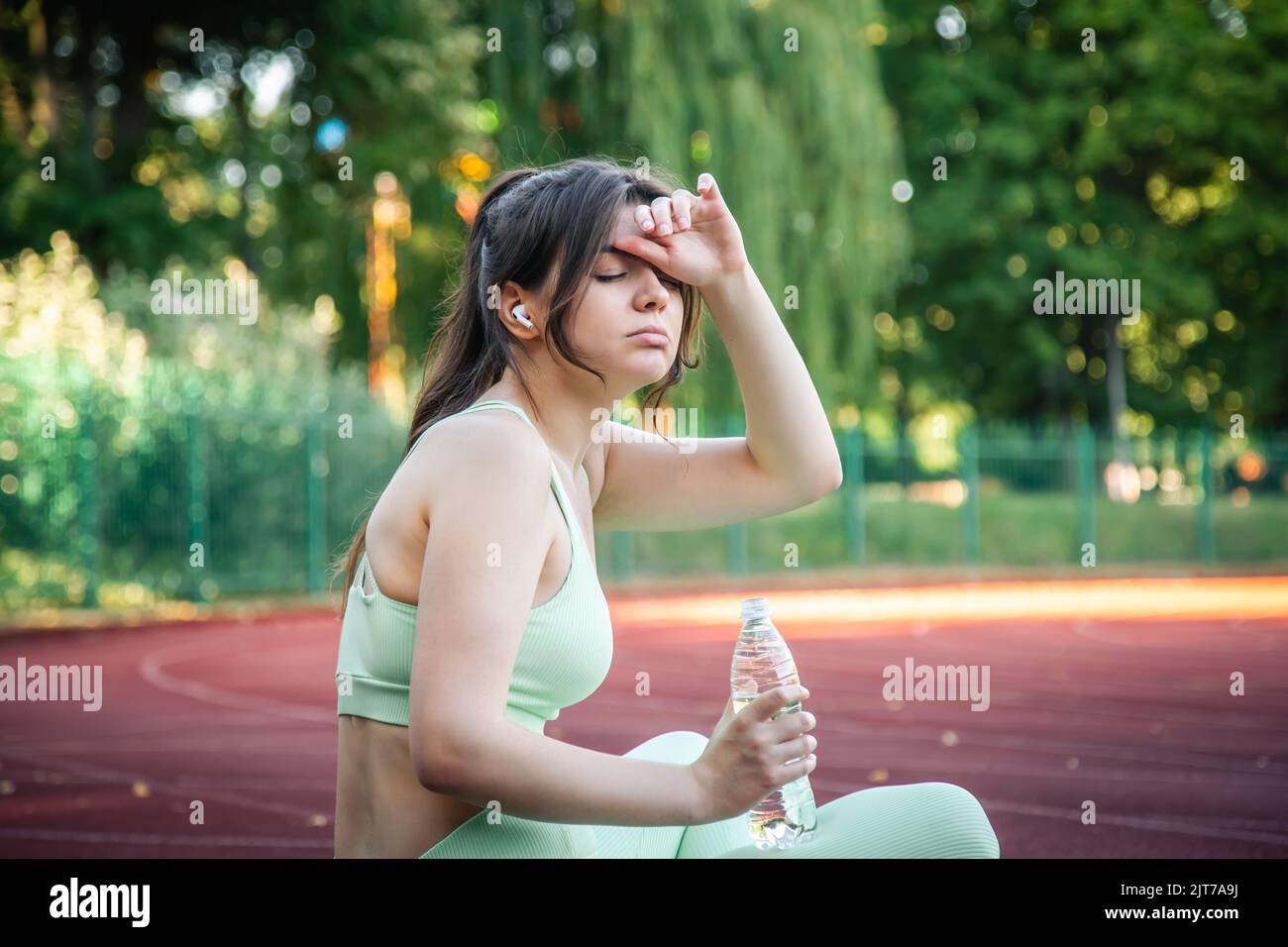 Tired attractive woman after jogging at the stadium Stock Photo - Alamy