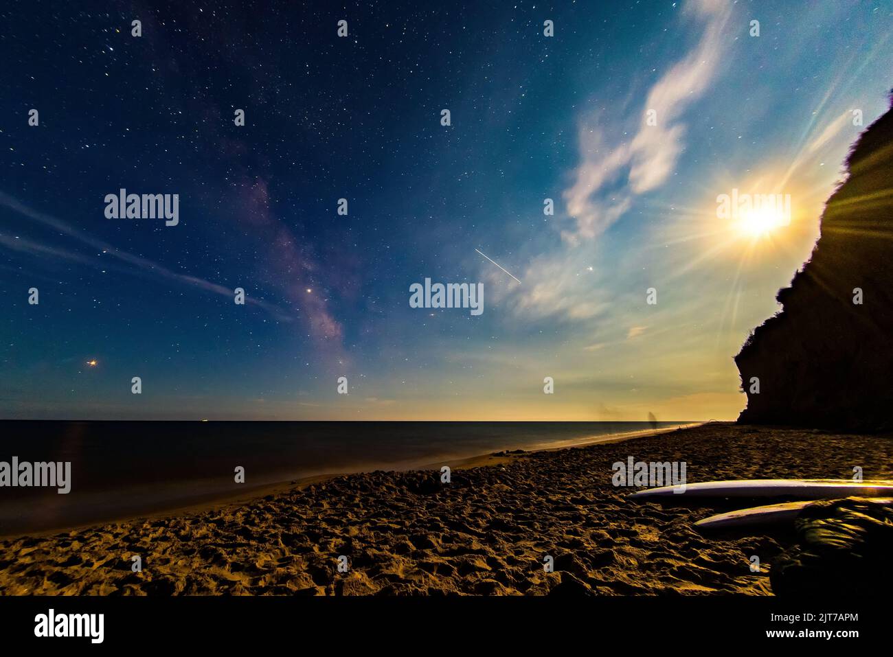 Milky Way and Moon closely shine over the sea beach at night beautiful ...