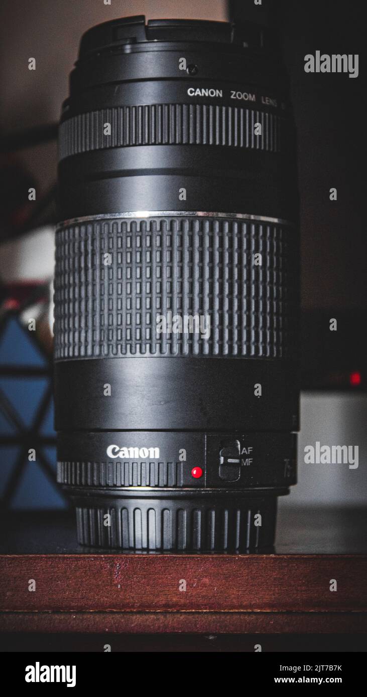 A vertical shot of a Canon lens on a desk Stock Photo - Alamy